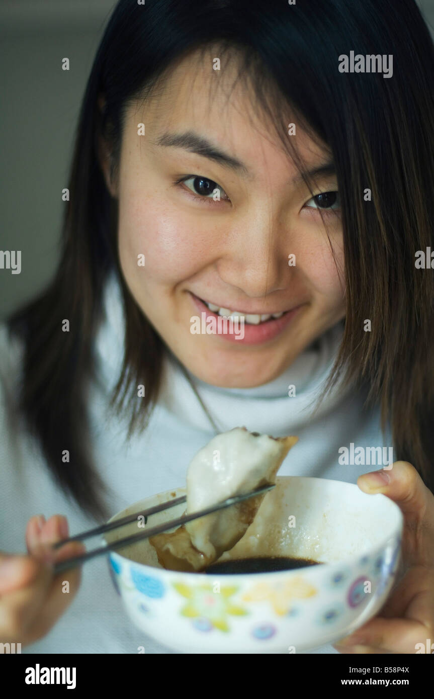 A Chinese girl eating dumplings, which are eaten traditionally on the ...