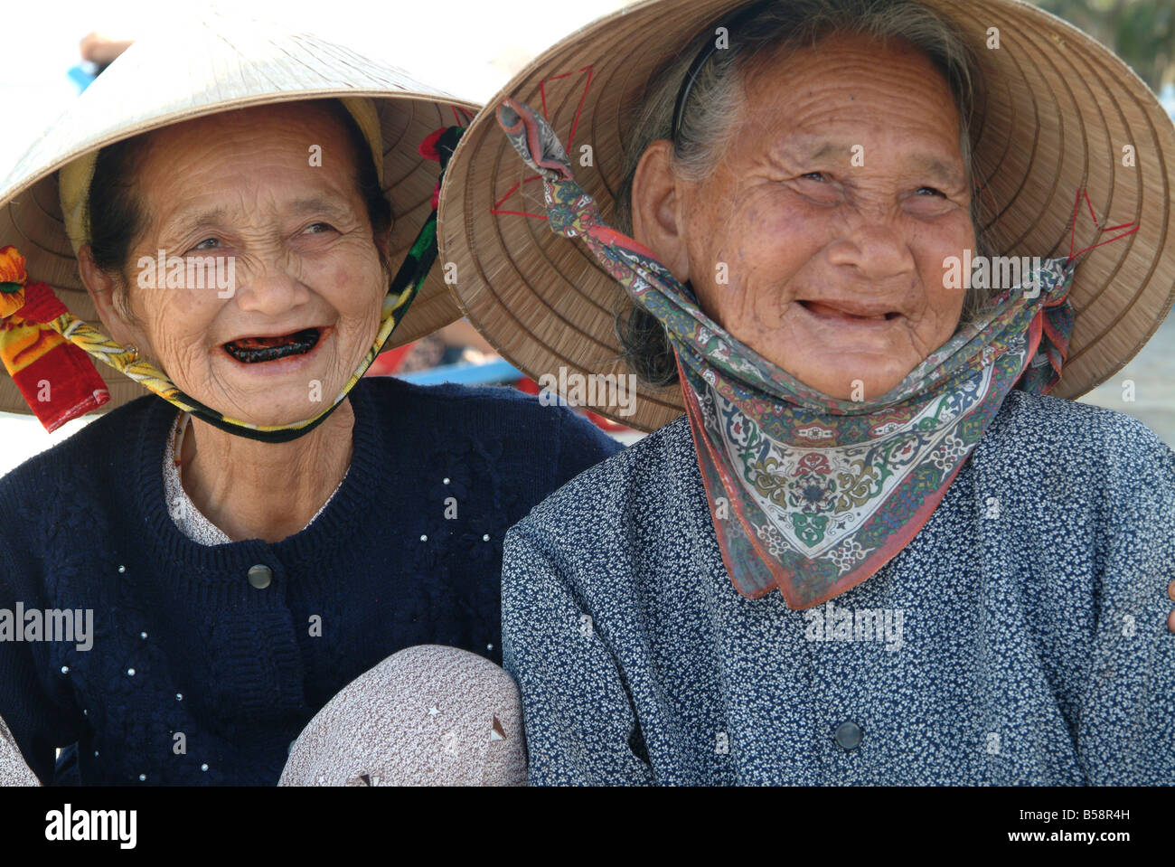 Two Vietnamese ladies smiling with hats on Stock Photo - Alamy