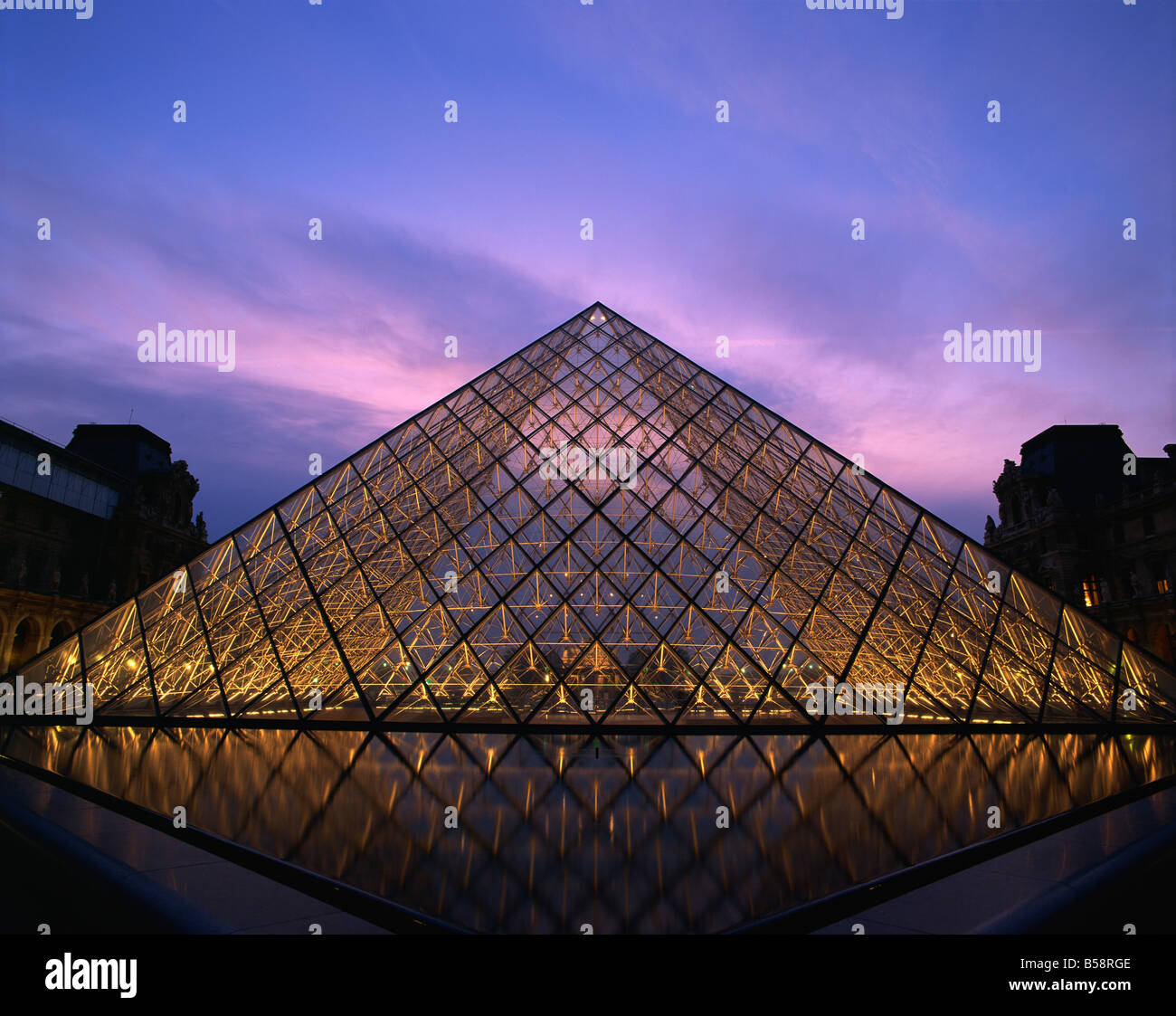 The Pyramide du Louvre illuminated at dusk Musee du Lourve Paris France ...