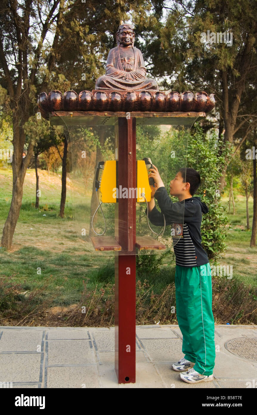 A boy using a monk decorated telephone box at Shaolin temple ...