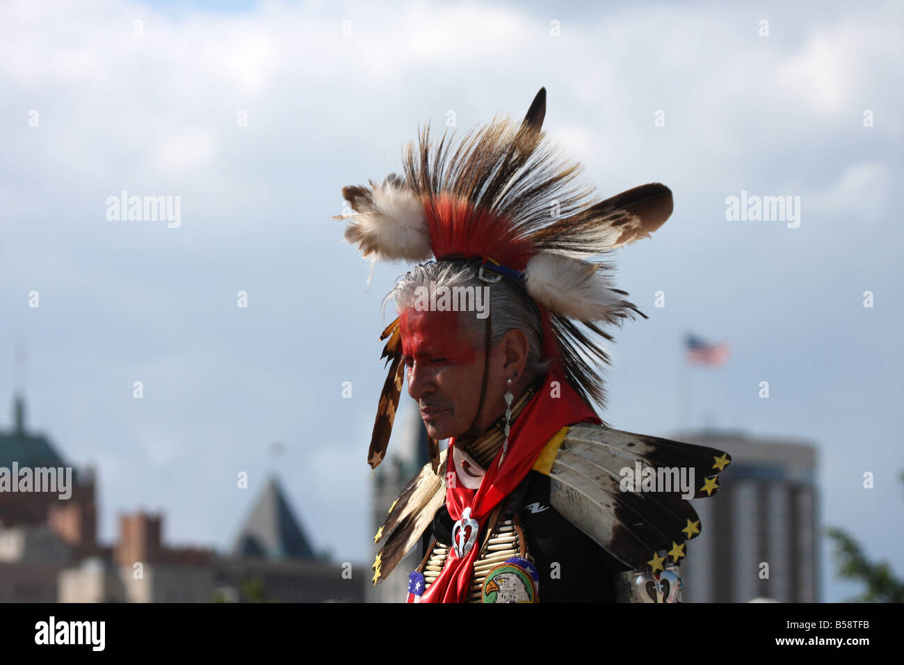 A Native American Indian man standing in front of the buildings at the ...