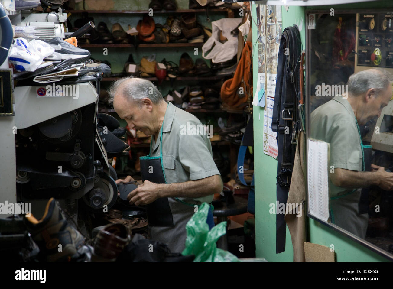 Busy cobbler, shoe repairer, working away in a side street in Barcelona ...