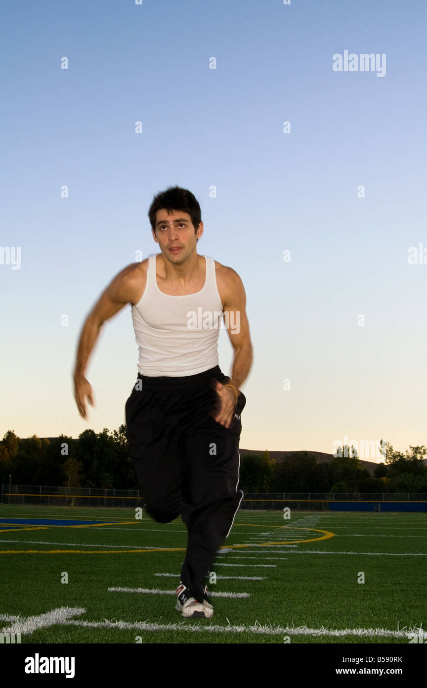 Young Man running down field Stock Photo - Alamy