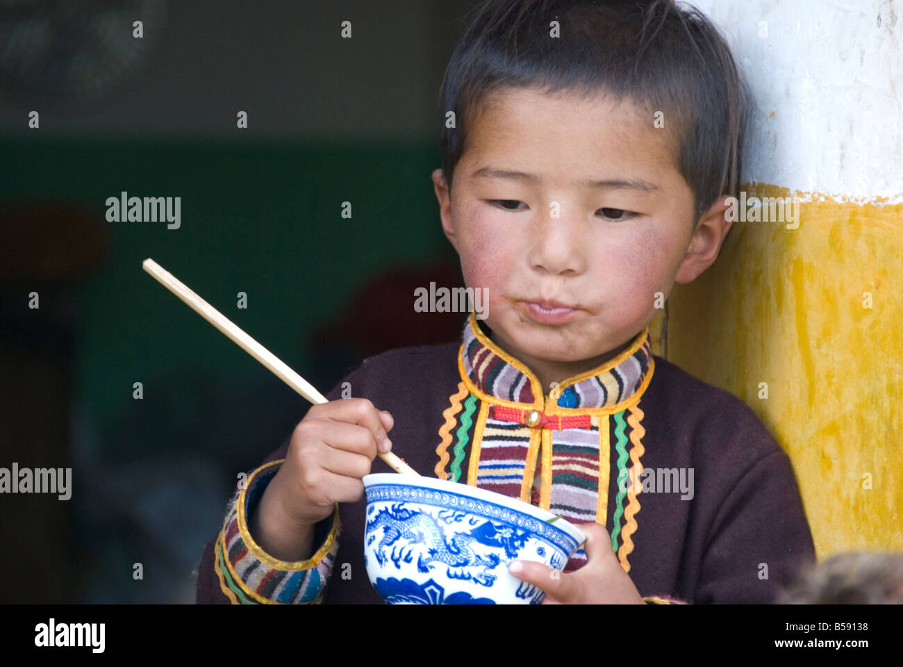Tibetan child eating rice hi-res stock photography and images - Alamy