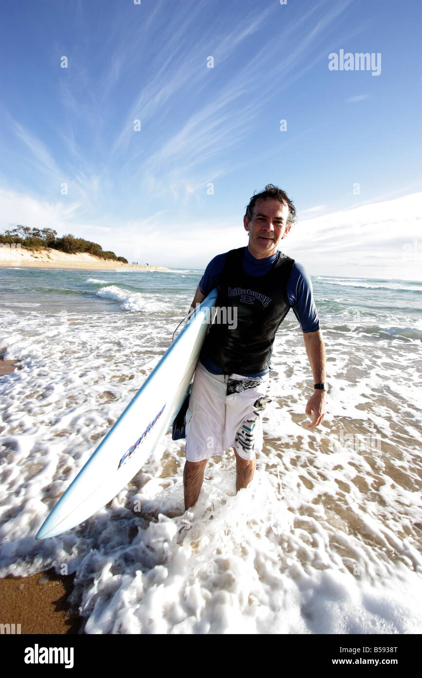 PORTRAIT OF A 50 SOMETHING MALE EMERGING FROM THE SURF VERTICAL ...