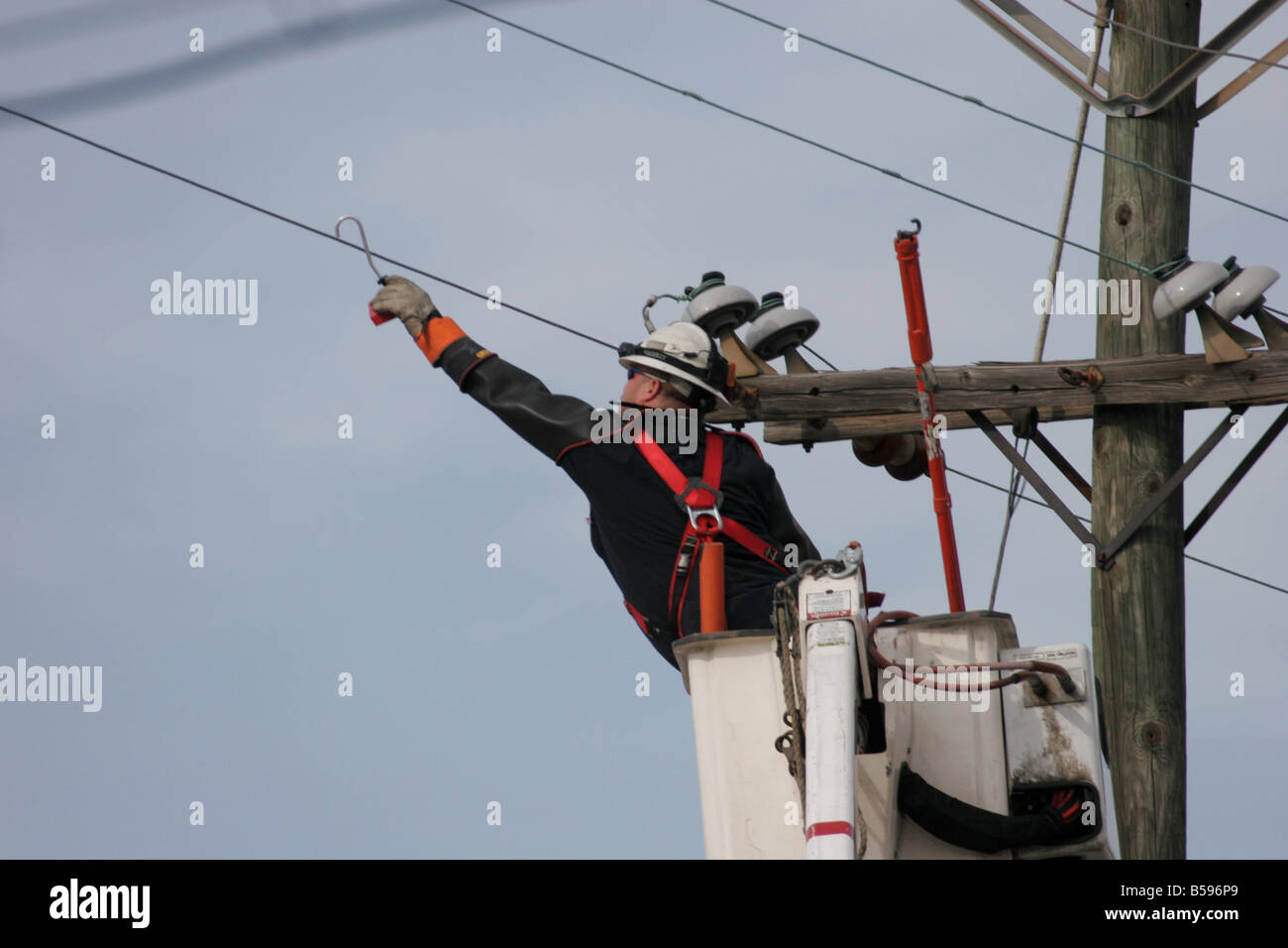 Utility worker repairing power lines after an accident where a truck ...