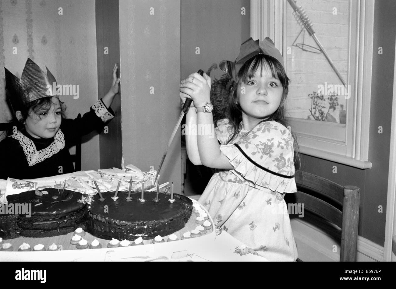 Childrens birthday party: The birthday girl cuts the cake. March 1981 ...