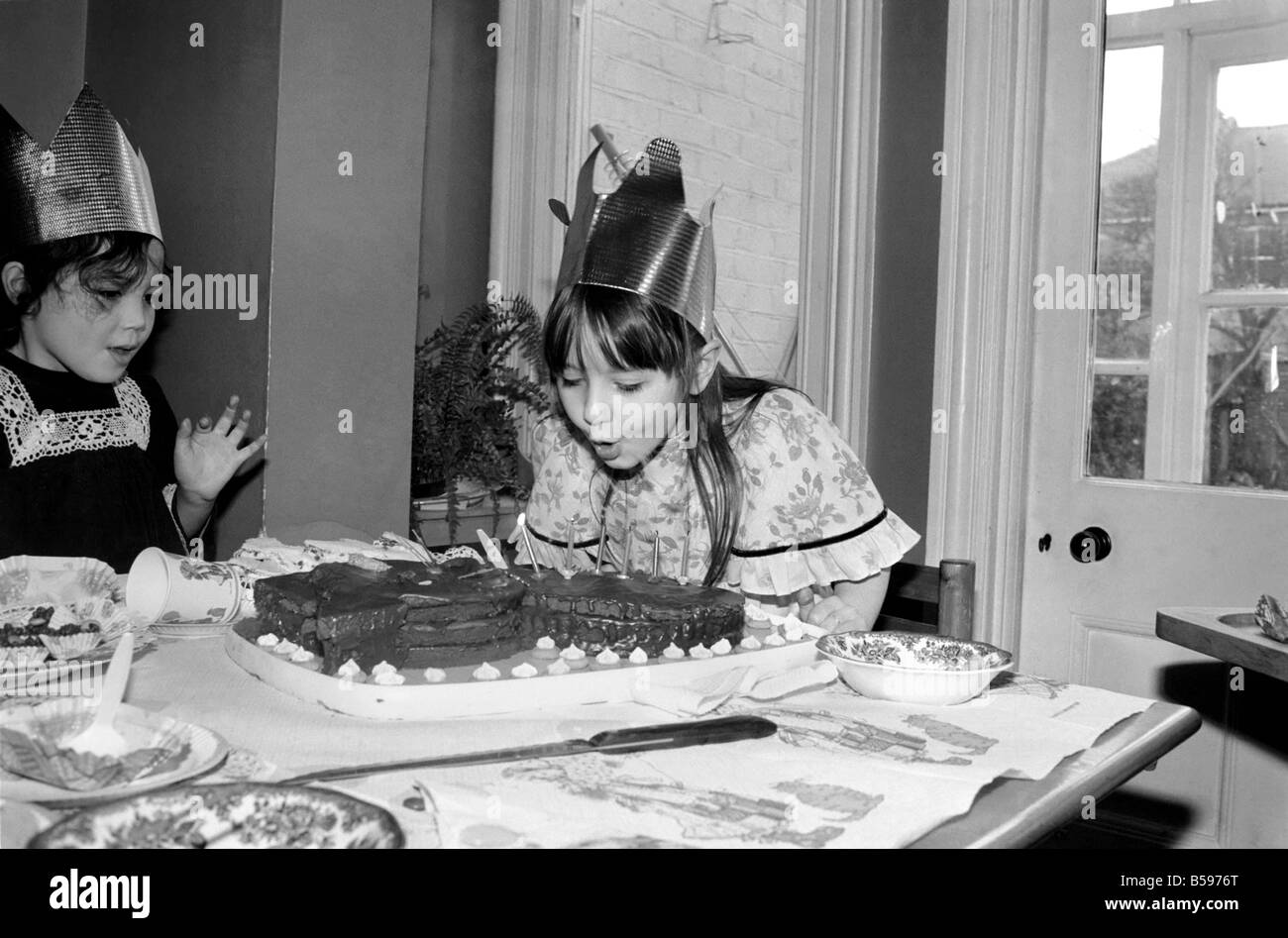 Childrens birthday party: The birthday girl cuts the cake. March 1981 ...