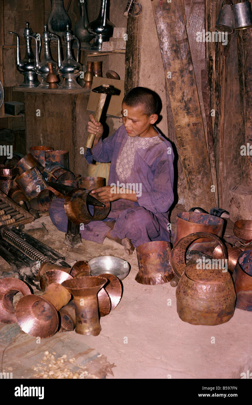 A boy hammering out a copper pot in Tashkurgan, Afghanistan Stock Photo ...