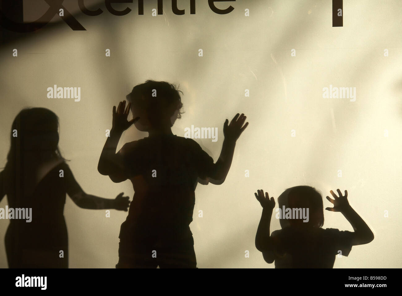Three young children playing with shadow silhouettes outside Brisbane ...