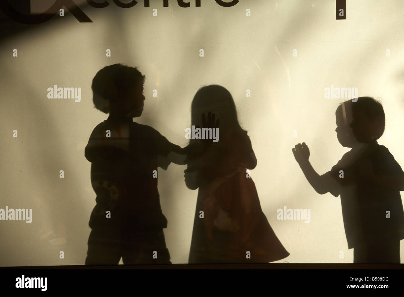 Three young children playing with shadow silhouettes outside Brisbane ...