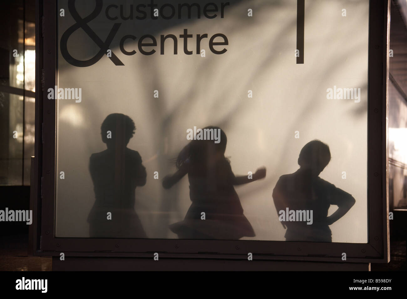 Three young children dancing with shadow silhouettes outside Brisbane ...