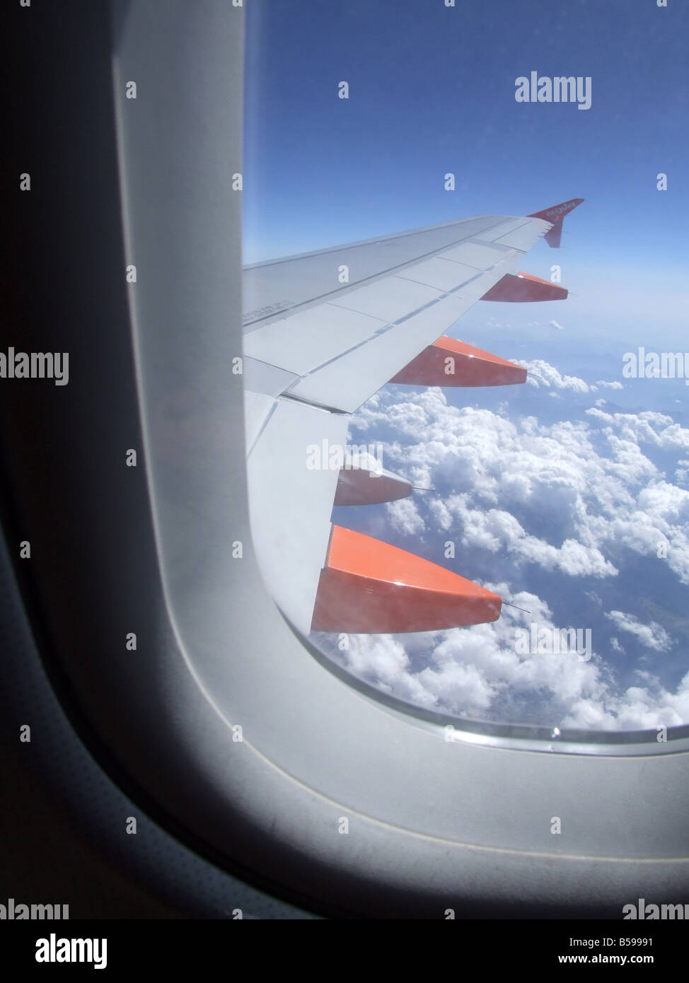 easyjet plane wing in blue sky with clouds Stock Photo - Alamy