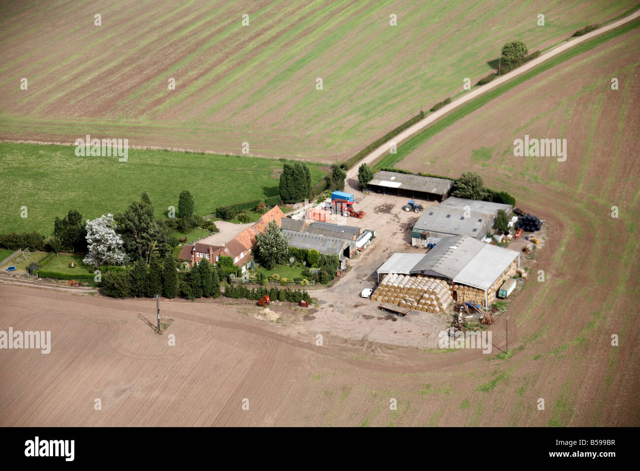 Aerial view north east of country farm tractor hay stacks fields ...