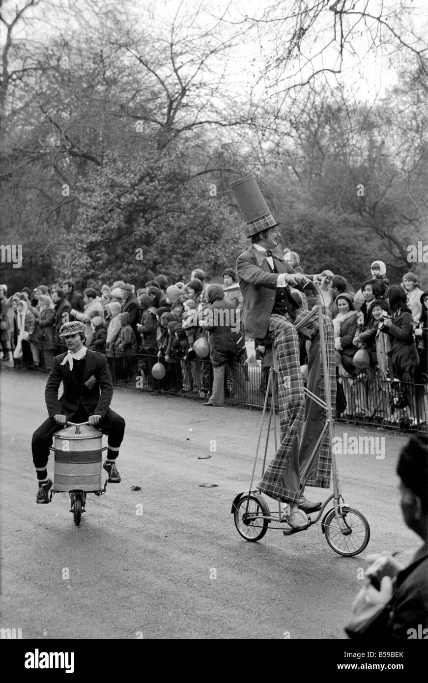 A clown stilt walker seen here riding a oversize bicycle in the Easter ...
