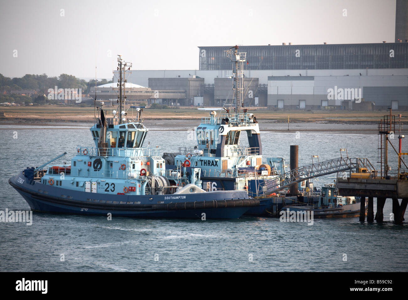 Merchant shipping tug boat vessel ships docked at Fawley oil refinery ...