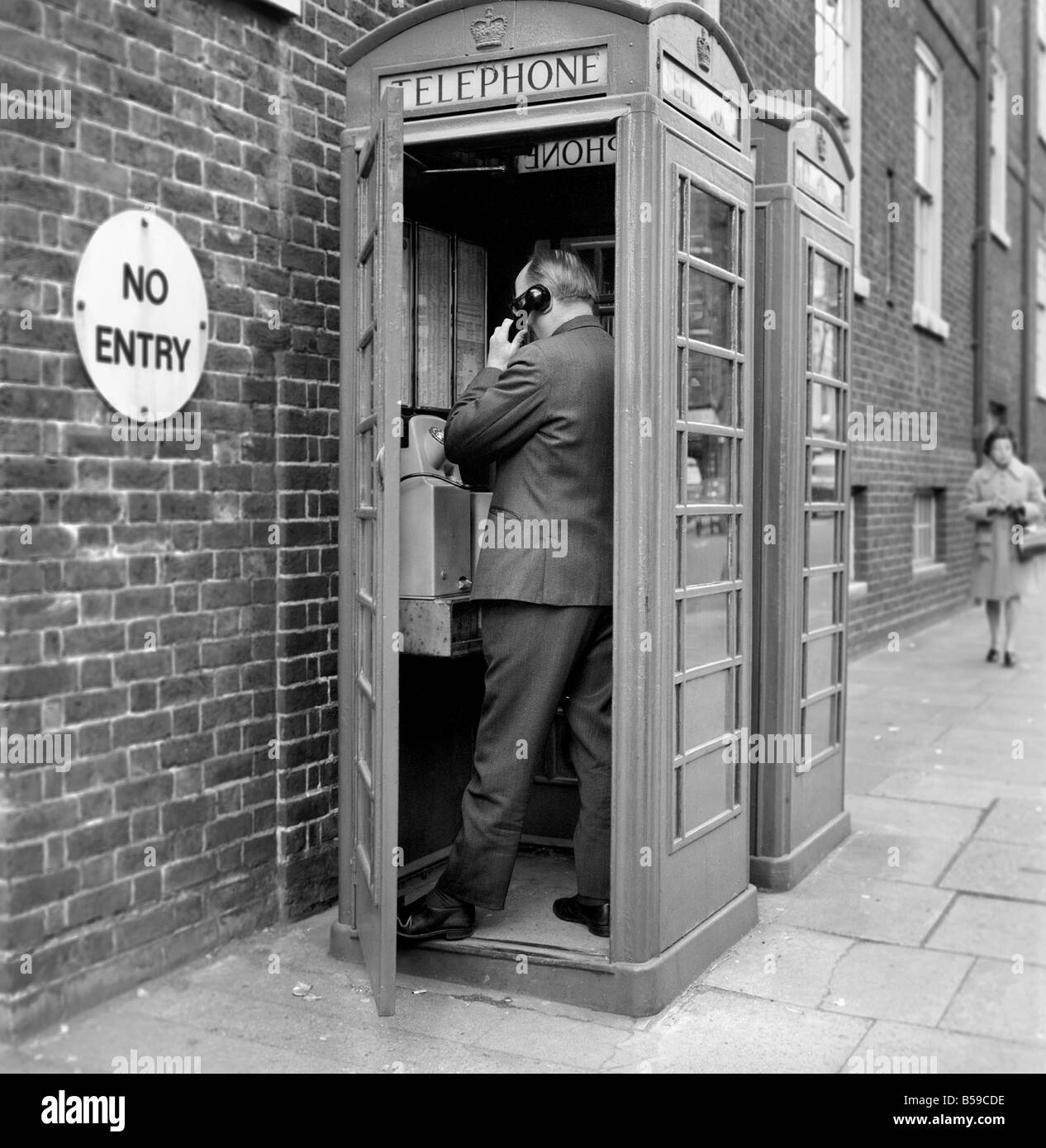 Man using a telephone box. The red telephone box was designed by Sir ...