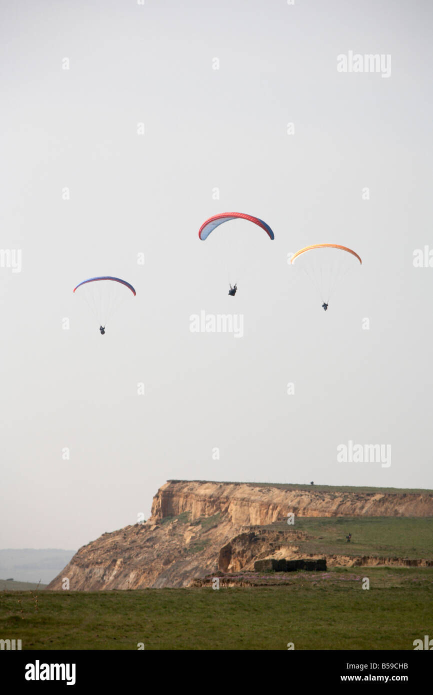 Pilots paragliding flying paragliders above Chale Bay south coast sea ...