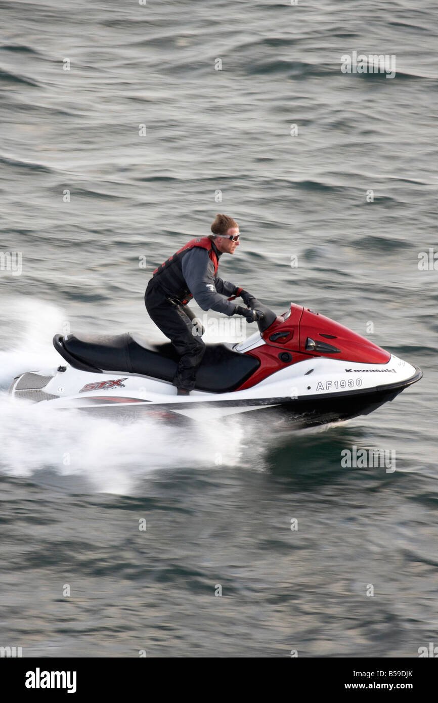 Man in wetsuit sailing jet ski motor speed boat fast on sea at ...