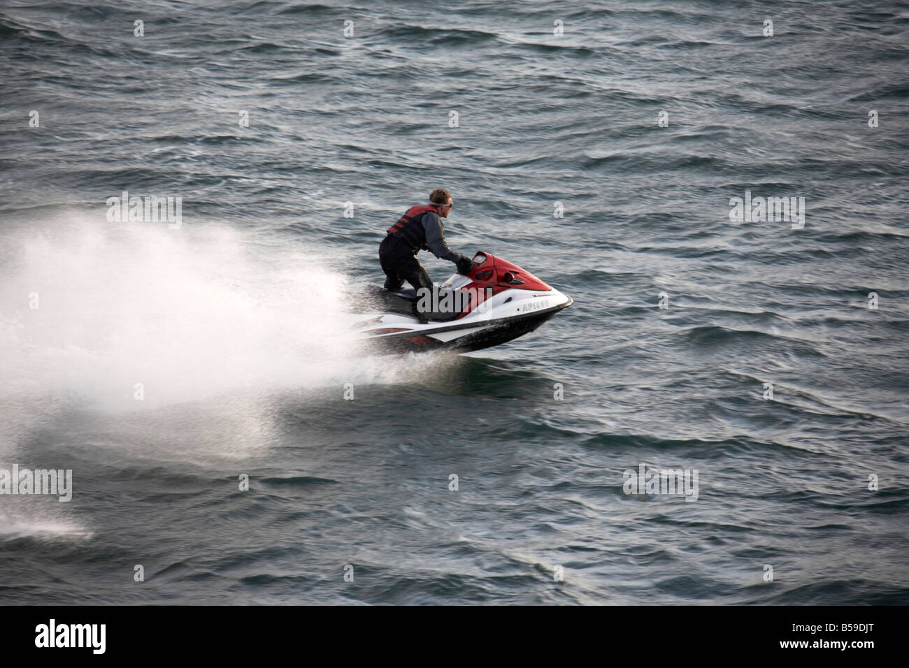 Man in wetsuit sailing jet ski motor speed boat fast on sea at ...