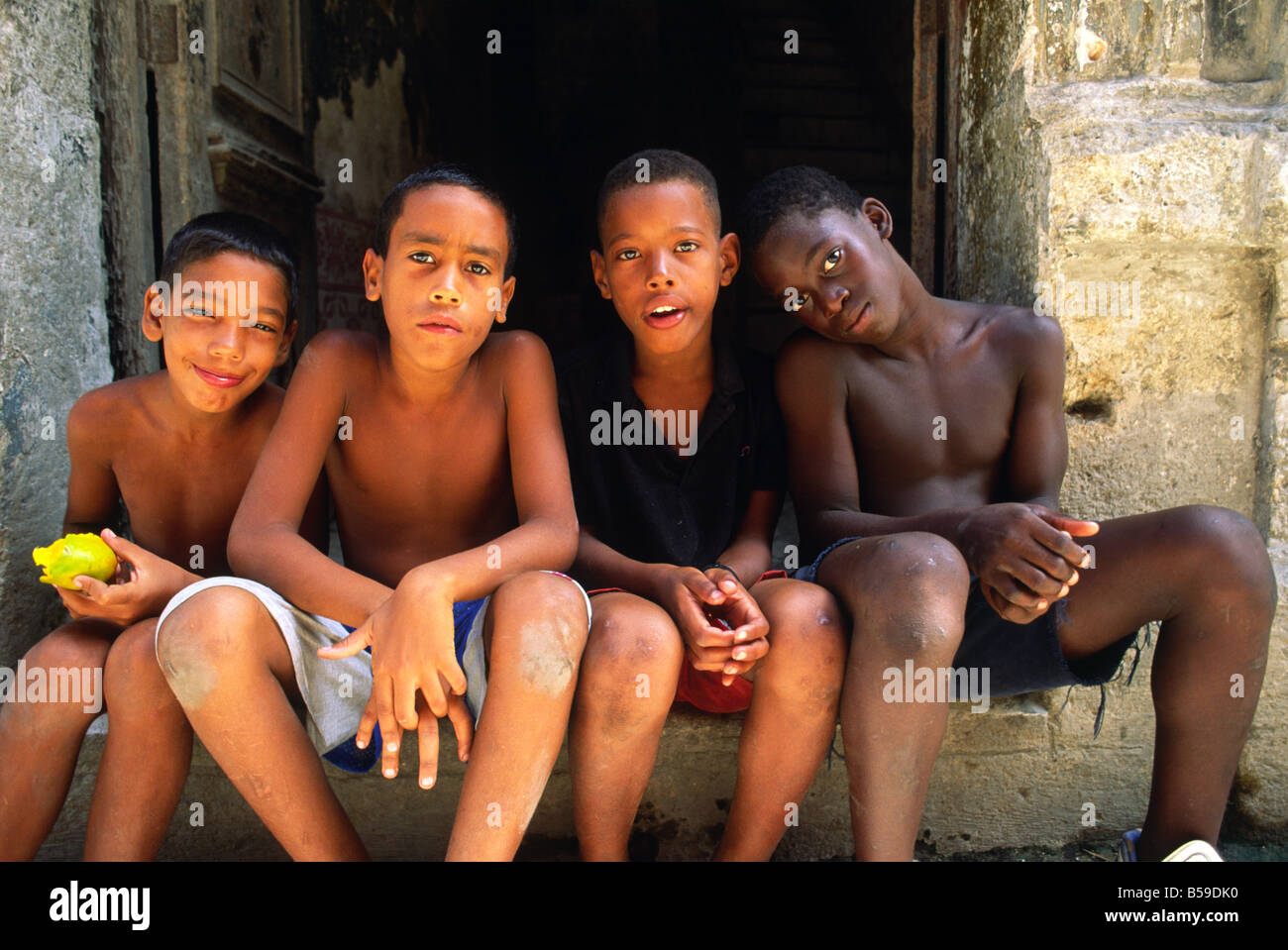 Young boys hang out in a door jamb in the colonial Old Town of Havana ...