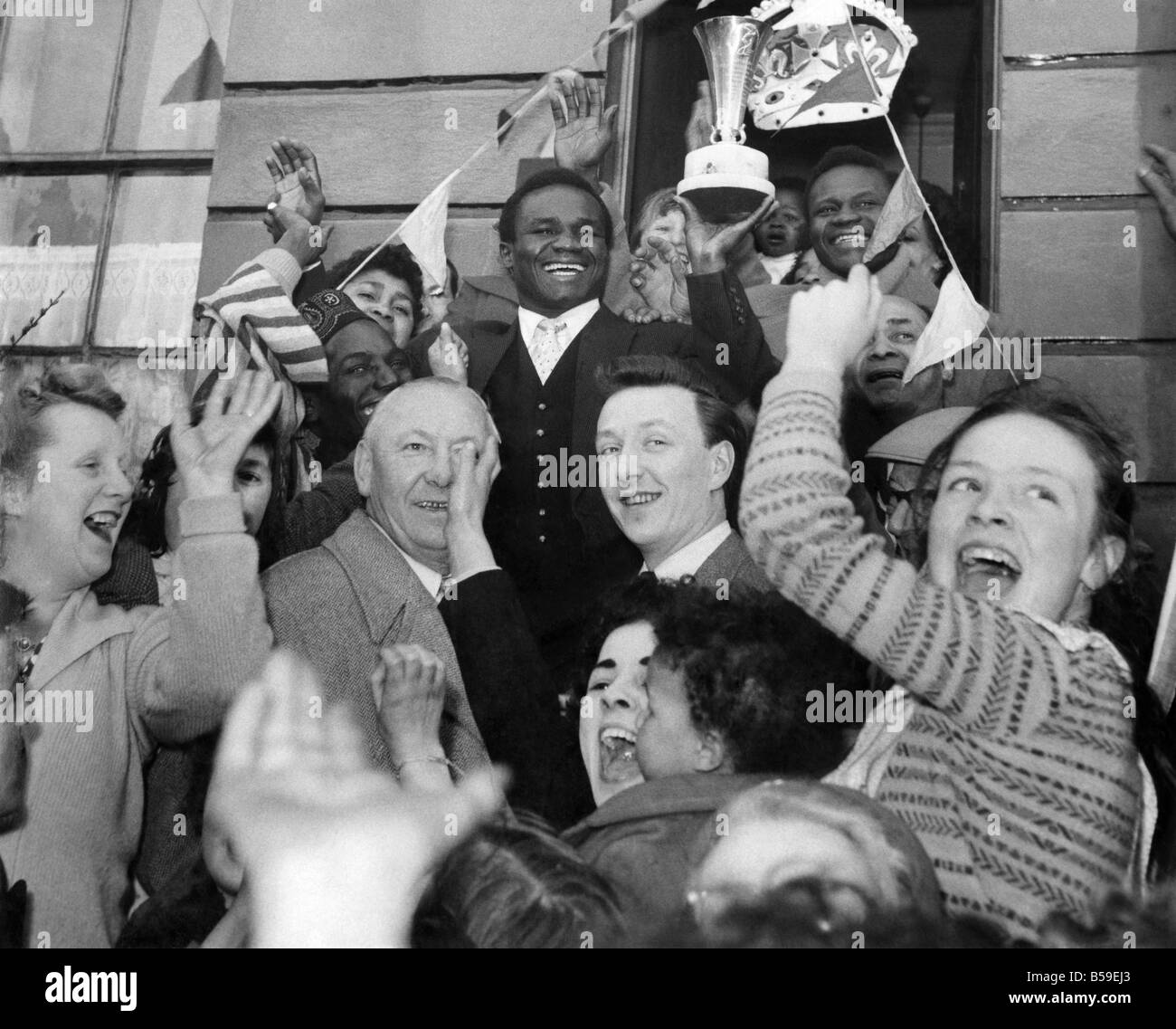Hogan "Kid" Bassey is cheered by neighbours as he arrives at his mother ...