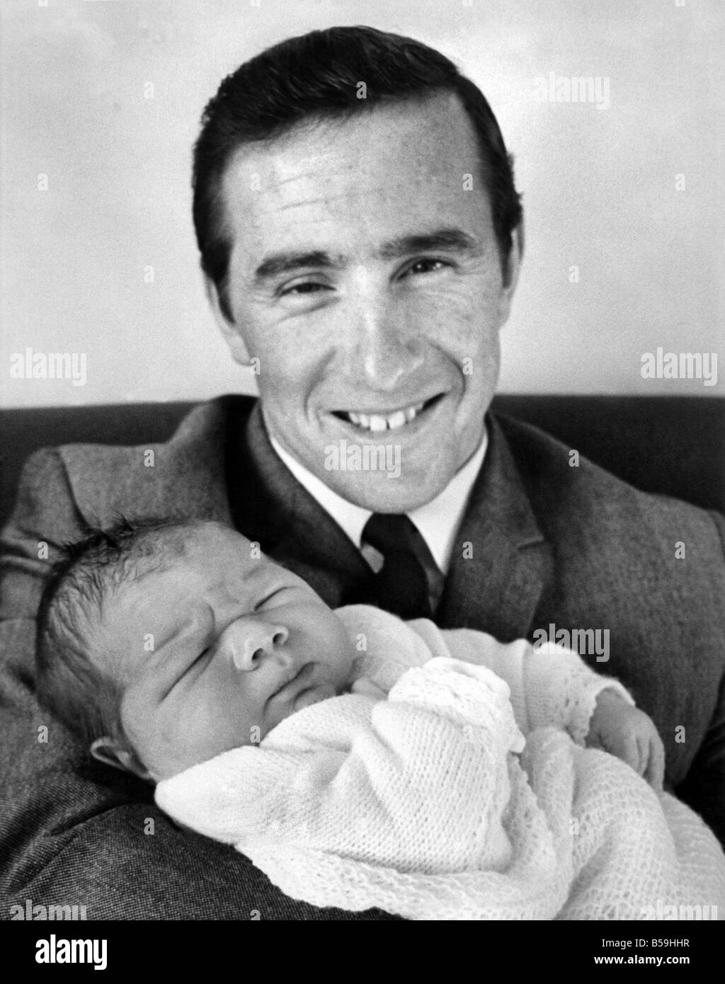 Proud father racing driver Jackie Stewart seen here holding his son ...