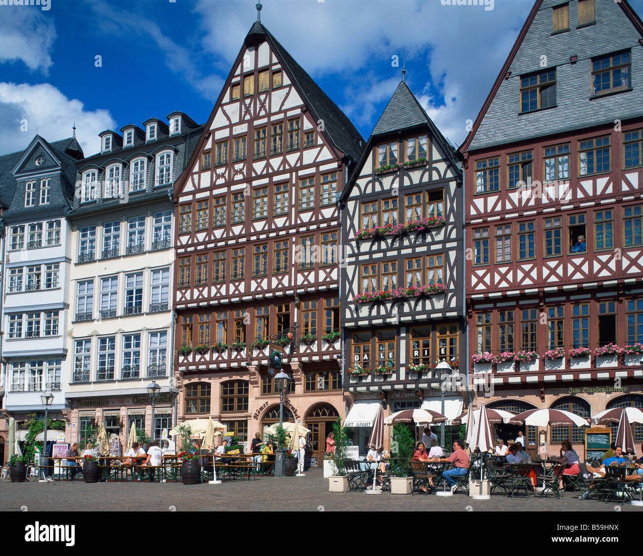 Street scene with pavement cafes bars and timbered houses in the Romer ...
