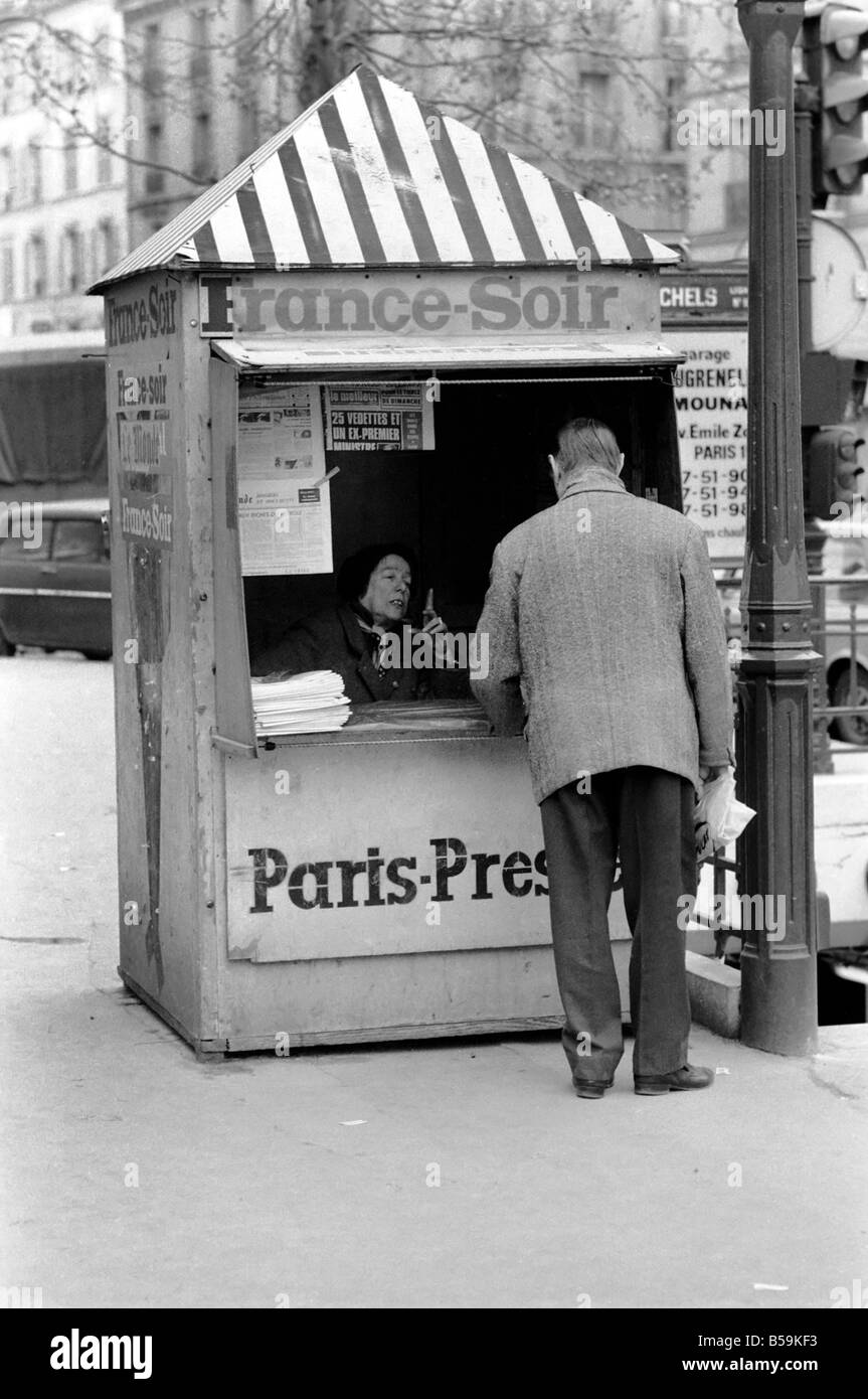 A Morning newspaper reader picks up his paper from a kiosk in the 15th ...
