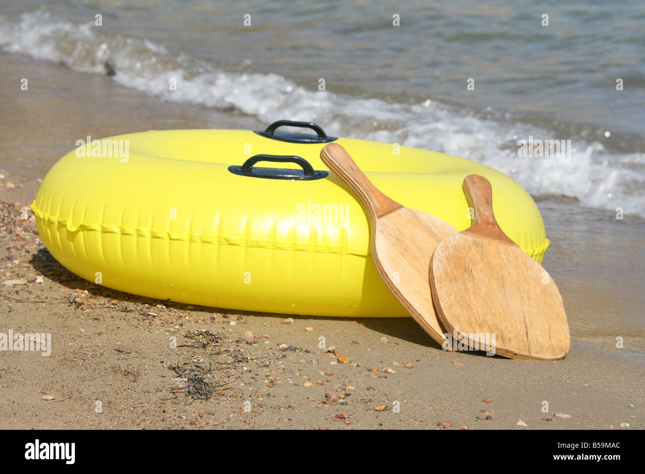 yellow inflatable by the sea and wooden beach tennis rackets Stock ...