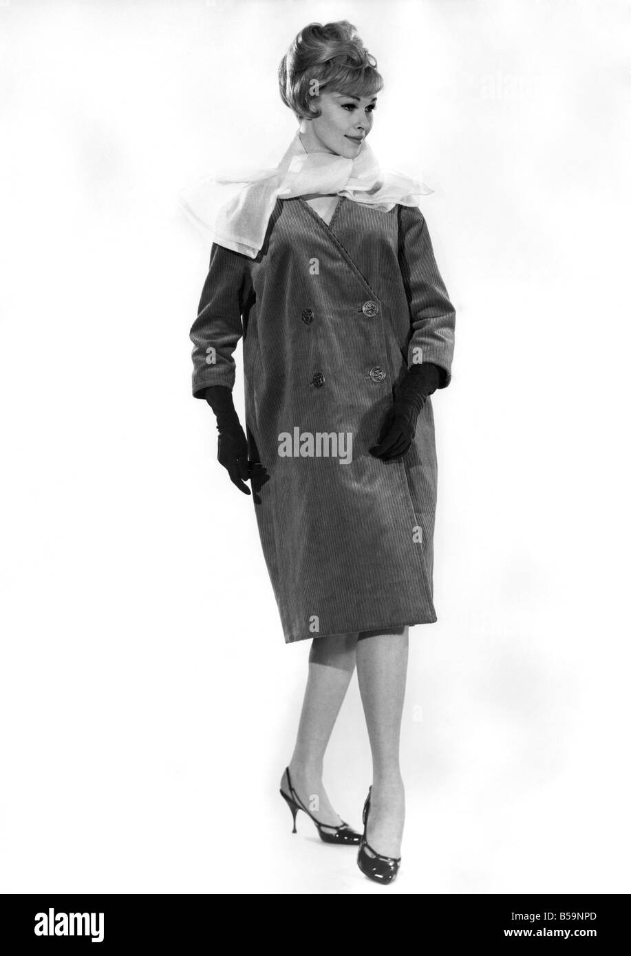 Model Jo Waring wearing a three quarter length buttoned coat with full ...