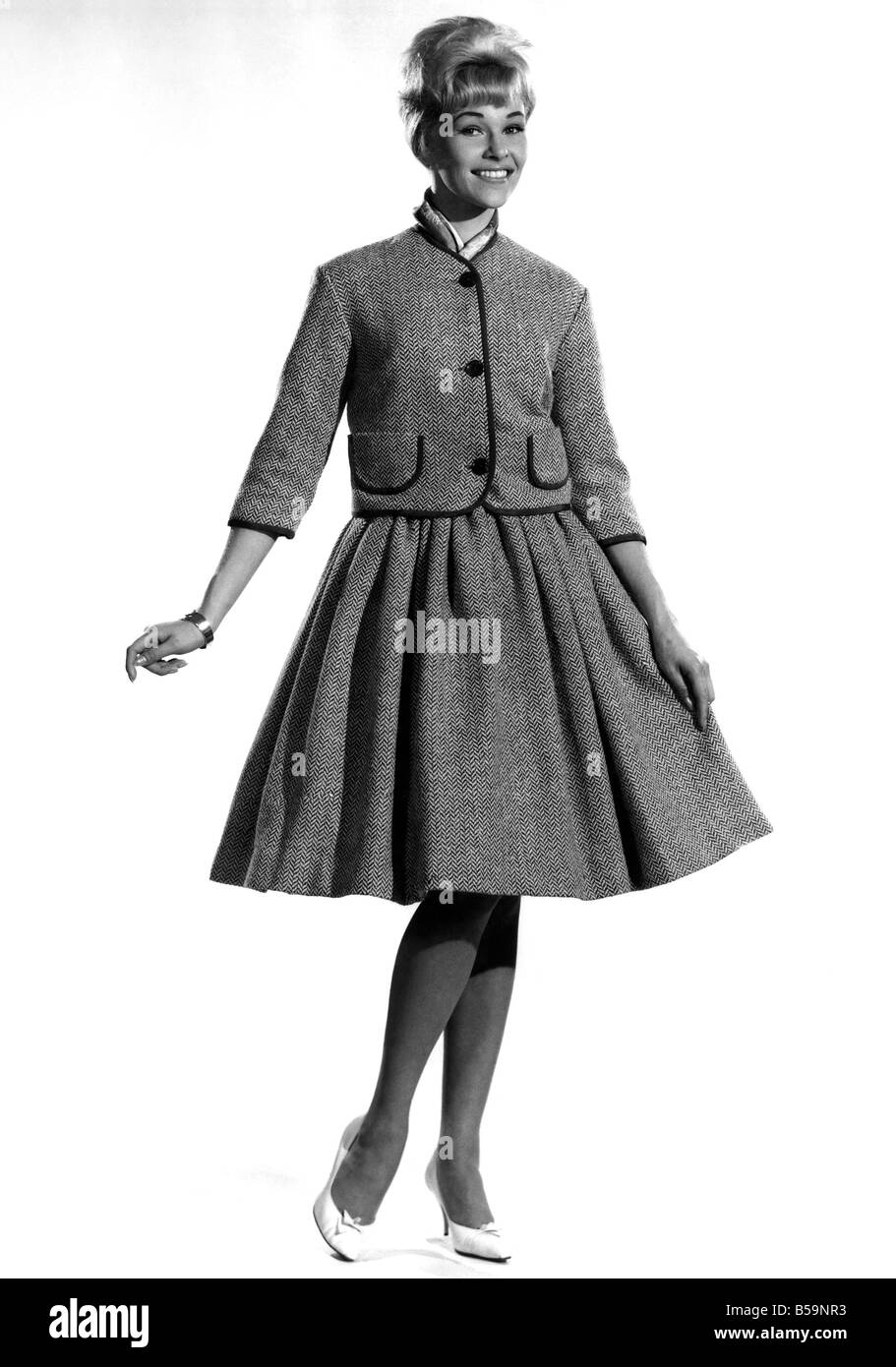 Model Jo Waring wearing a buttoned up jacket and matching skirt ...