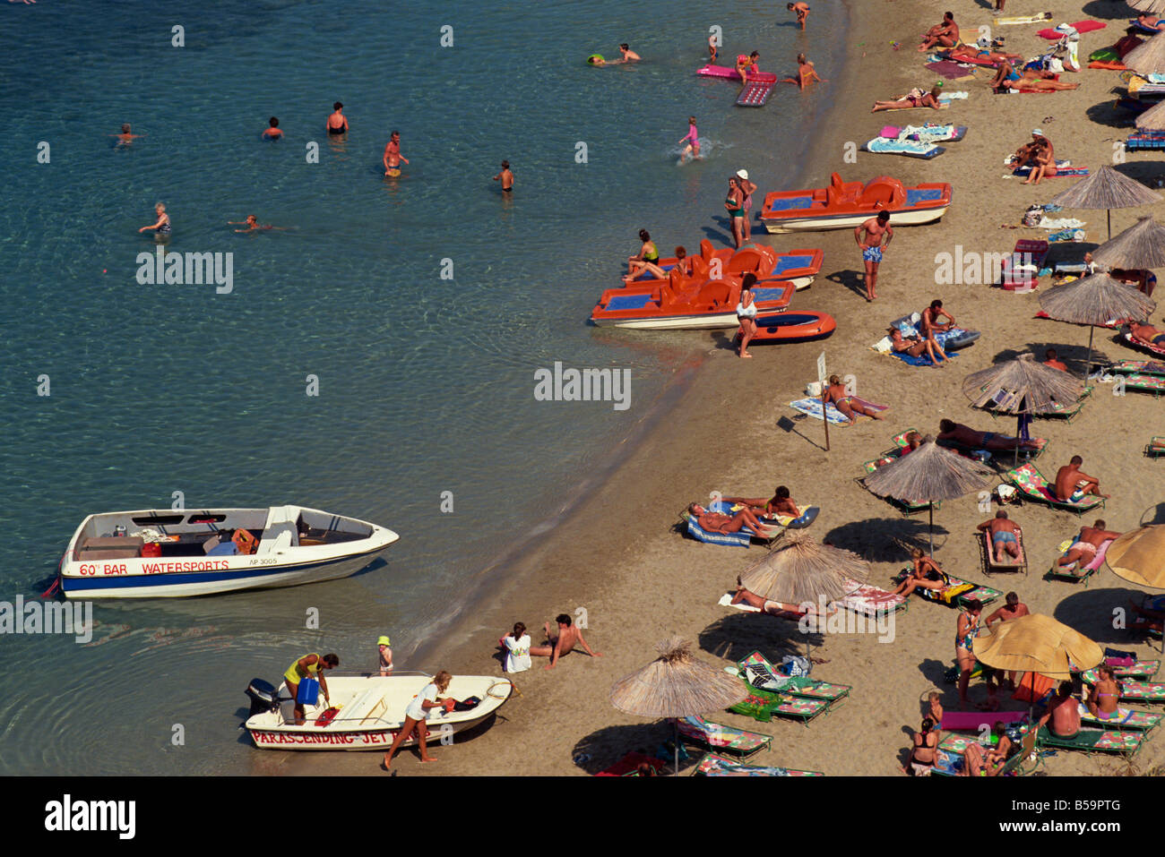 Aerial view over a crowded beach scene on the main beach at Lindos Town ...