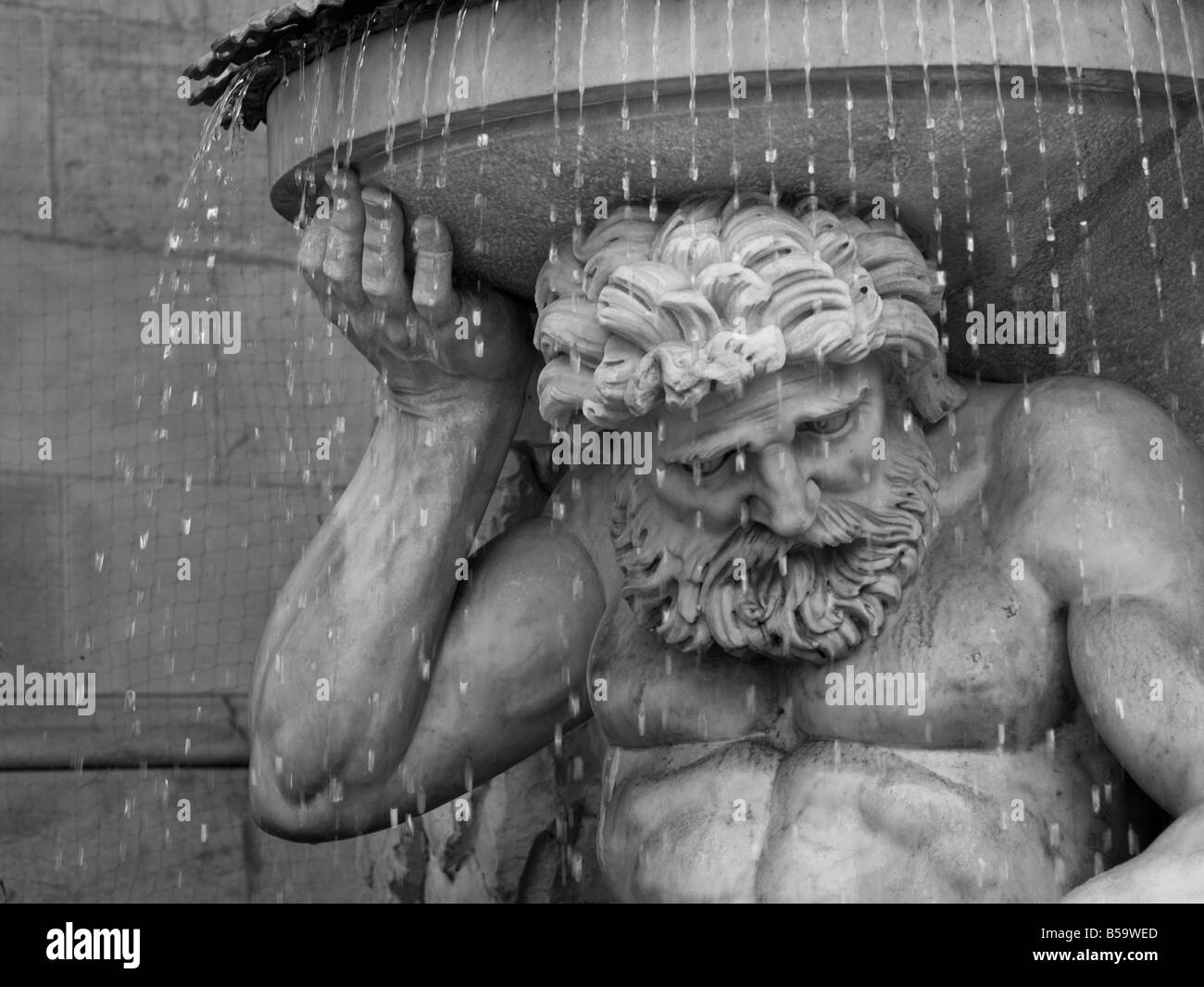 A statue of a man, holding a fountain Stock Photo - Alamy
