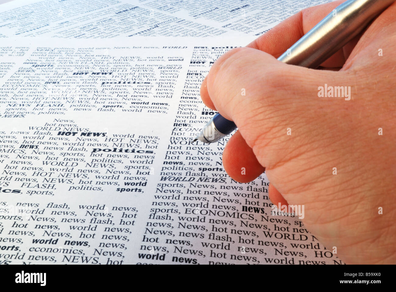 a hand holds a fountain pen above a newspaper closeup Stock Photo - Alamy