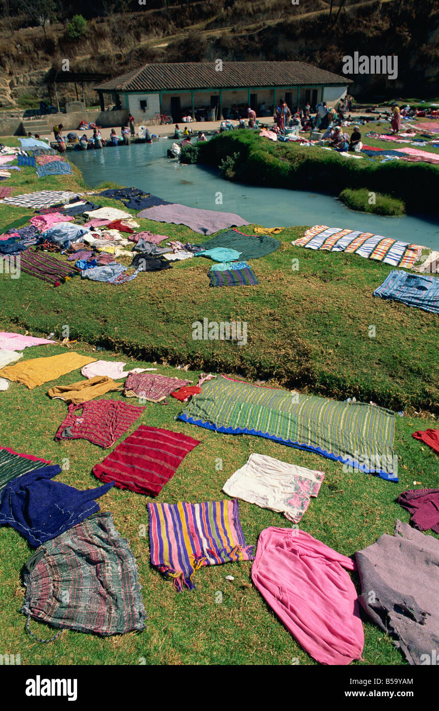 Public washing pool with laundry laid on the ground to dry near ...