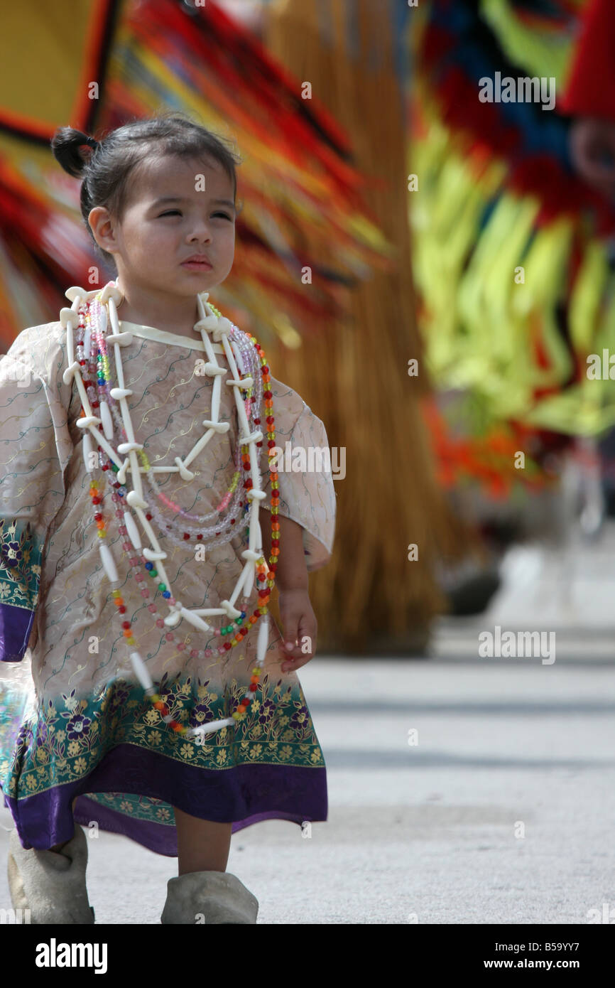 A young female Native American child in front of dancers at a Pow Wow ...