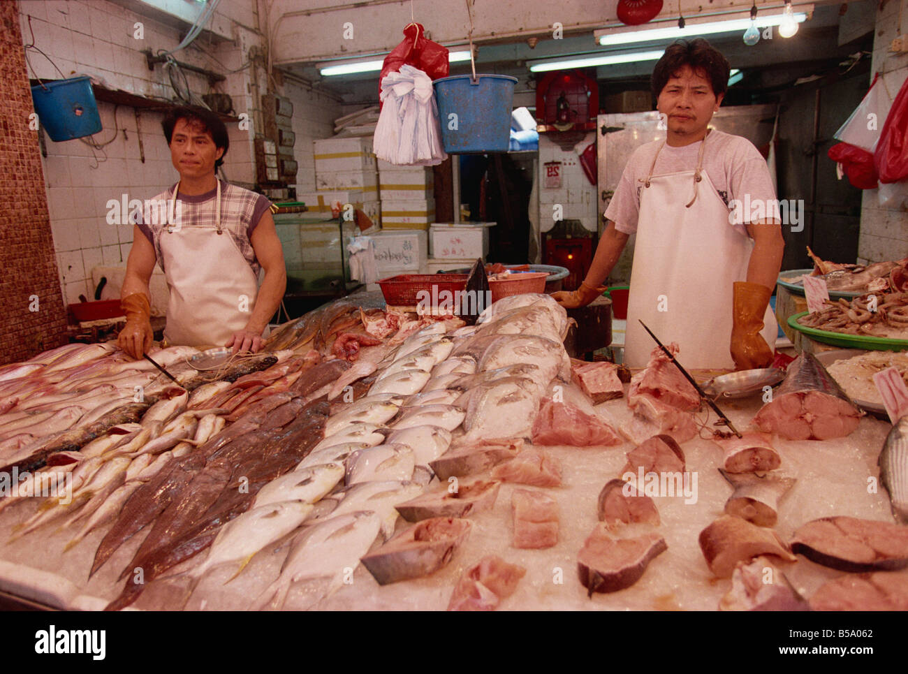 Two fishmongers with local fish for sale in a market in Hong Kong Asia ...