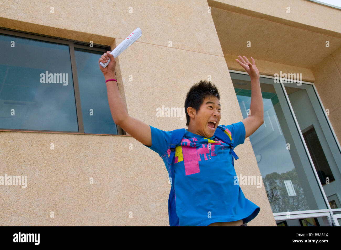 Teenage boy student jumps for joy at exam results Stock Photo - Alamy