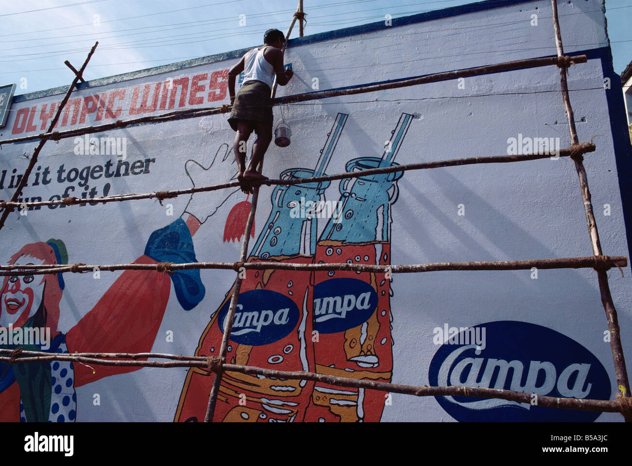 Hoarding artist painting a soft drinks advertisement on the side of a ...