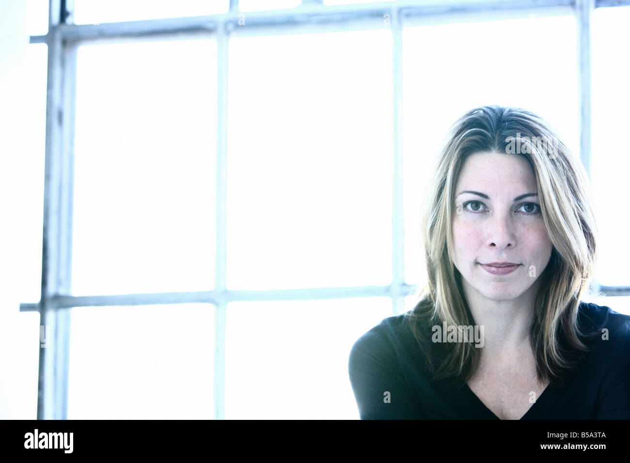 Young woman in front of window Stock Photo - Alamy