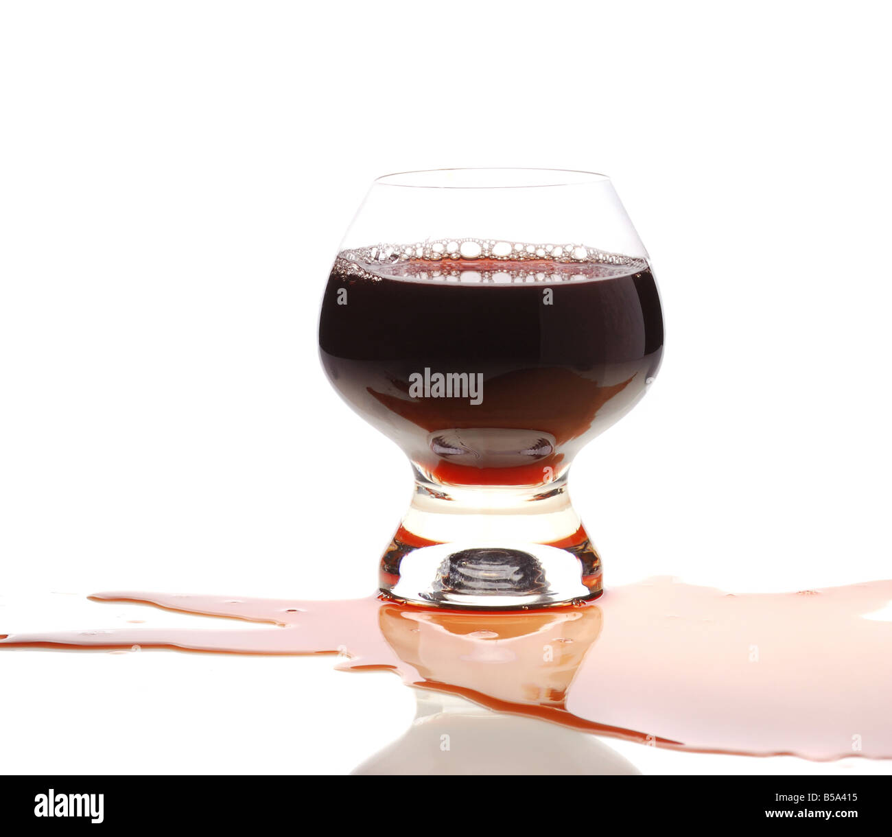 The spilled red wine Wine poured on a surface is isolated on a white ...