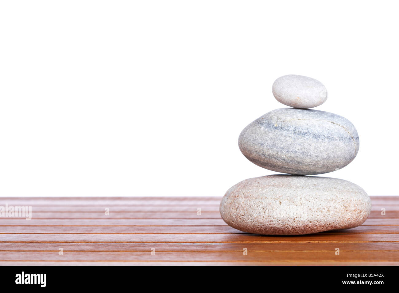 Stack of balanced stones with shadow on wooden background Stock Photo ...