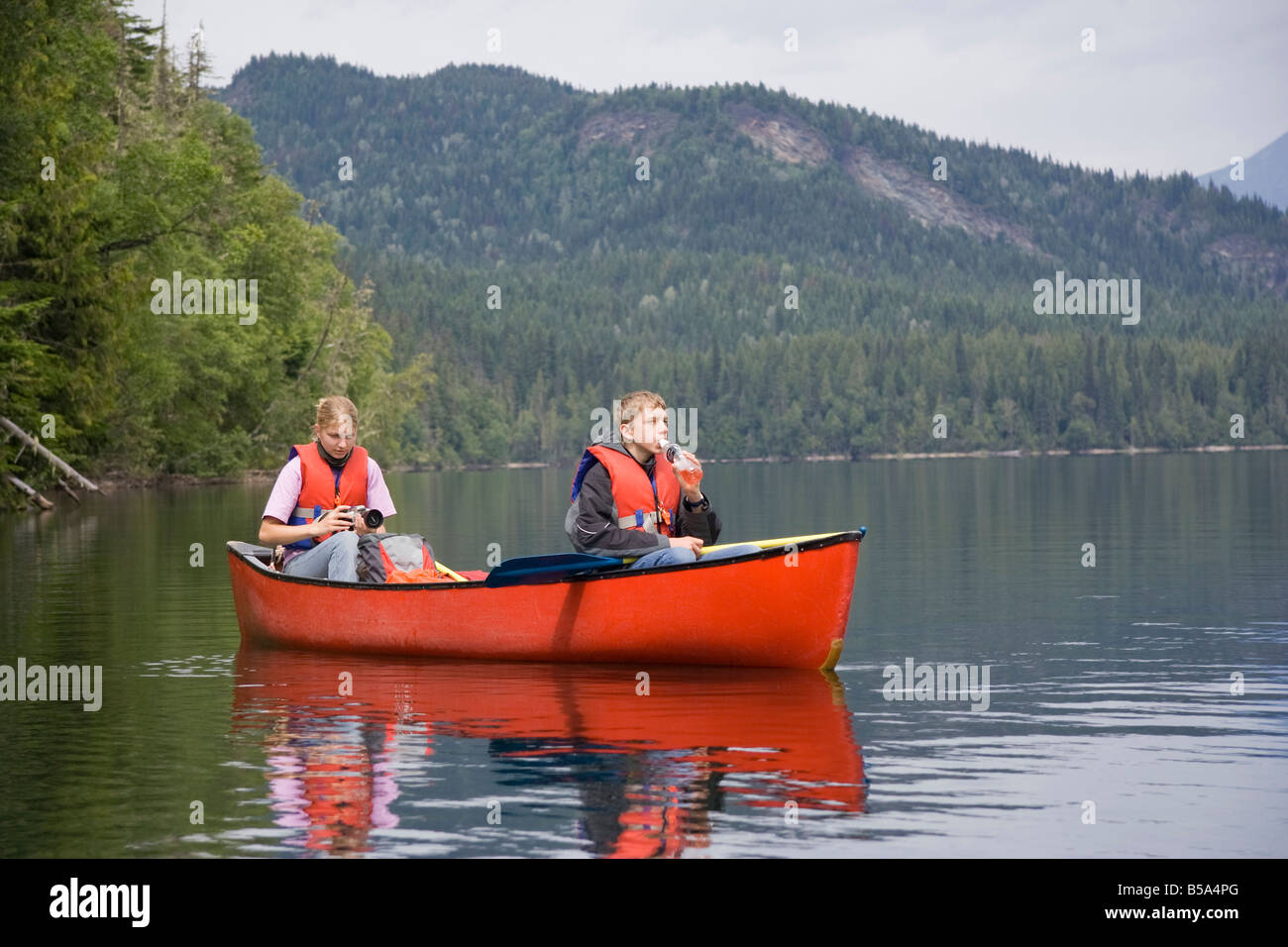 Girl and boy canoeing Clearwater Lake Wells Gray Provincial Park ...