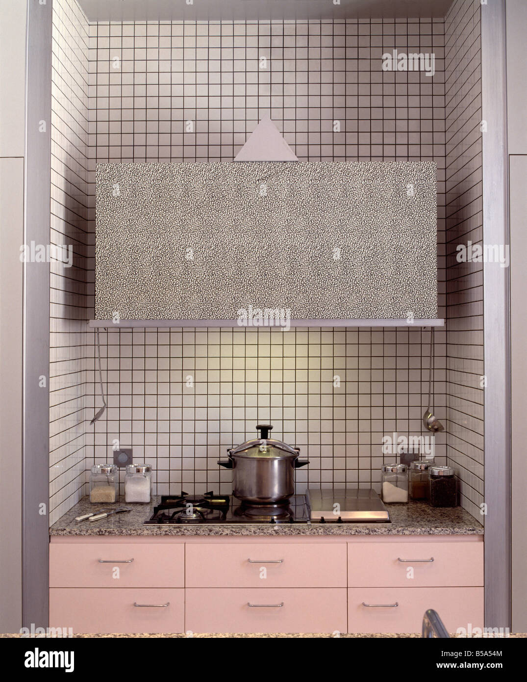 Speckled grey cover on extractor above pans on hob built into fitted ...