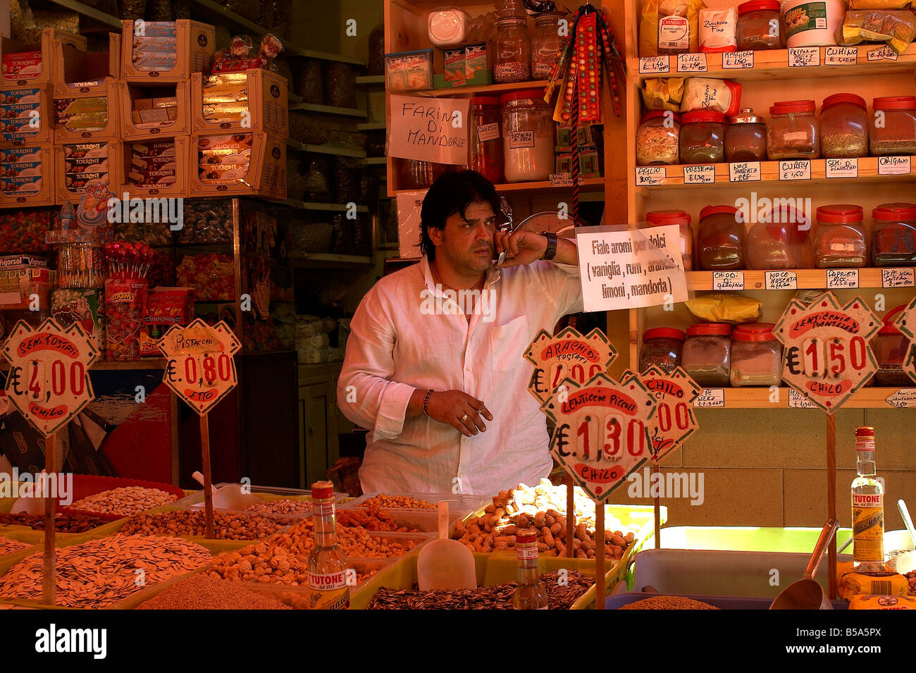 Market stall trader in Palermo Sicily has a mobile telephone ...