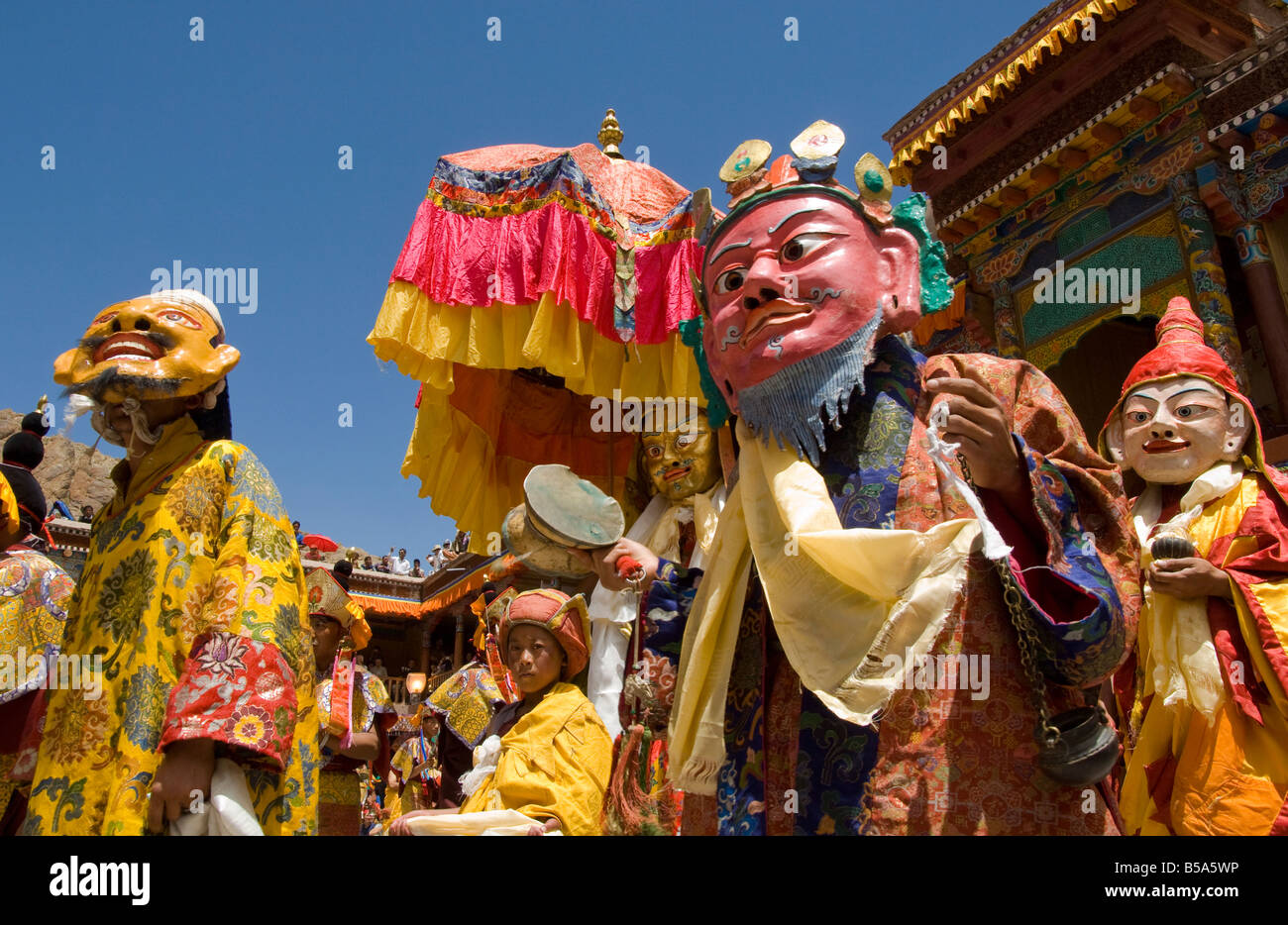 Group of monks in wooden masks and traditional costumes in procession ...
