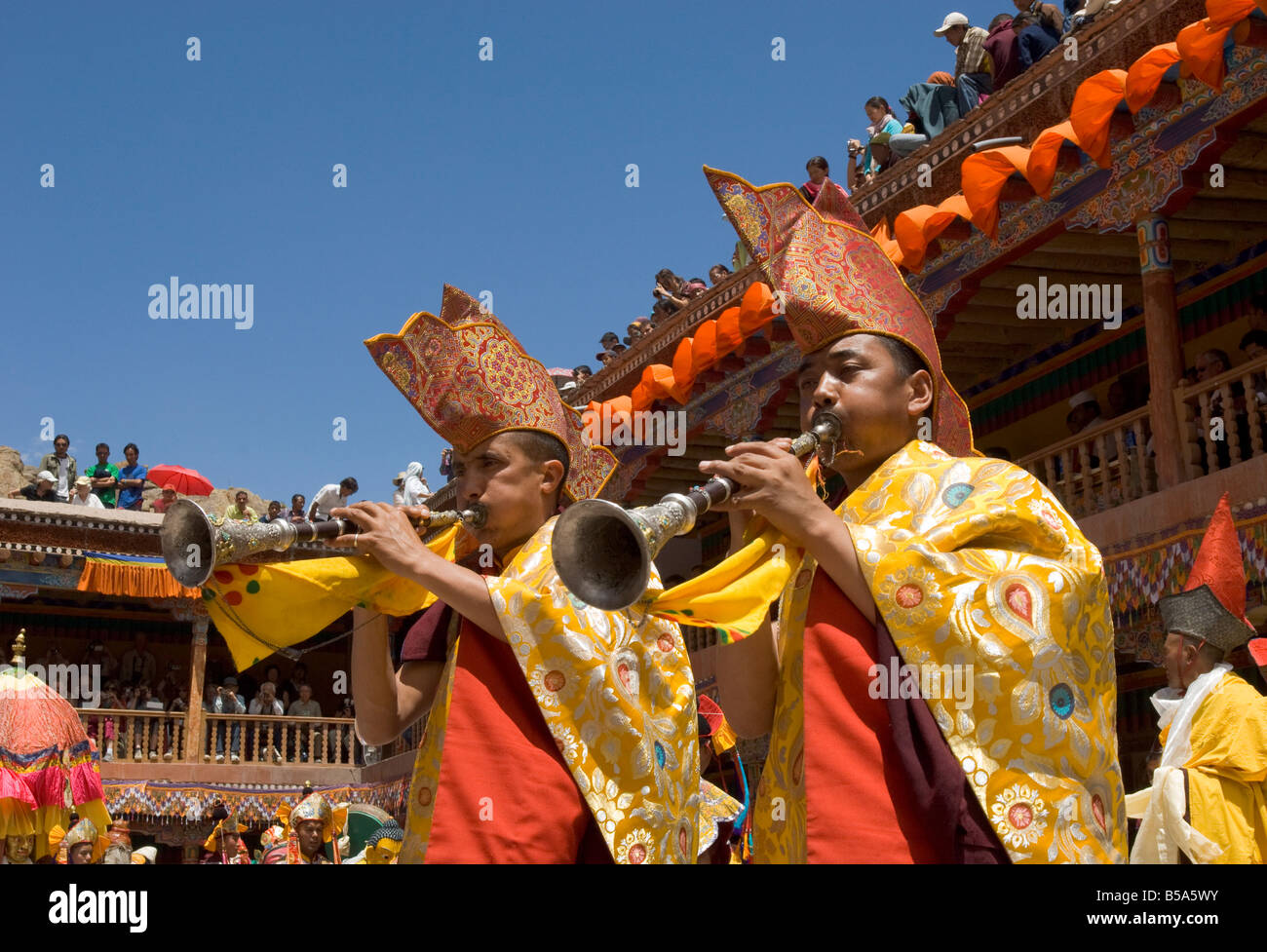 Procession in monastery courtyard with monk musicians blowing ...