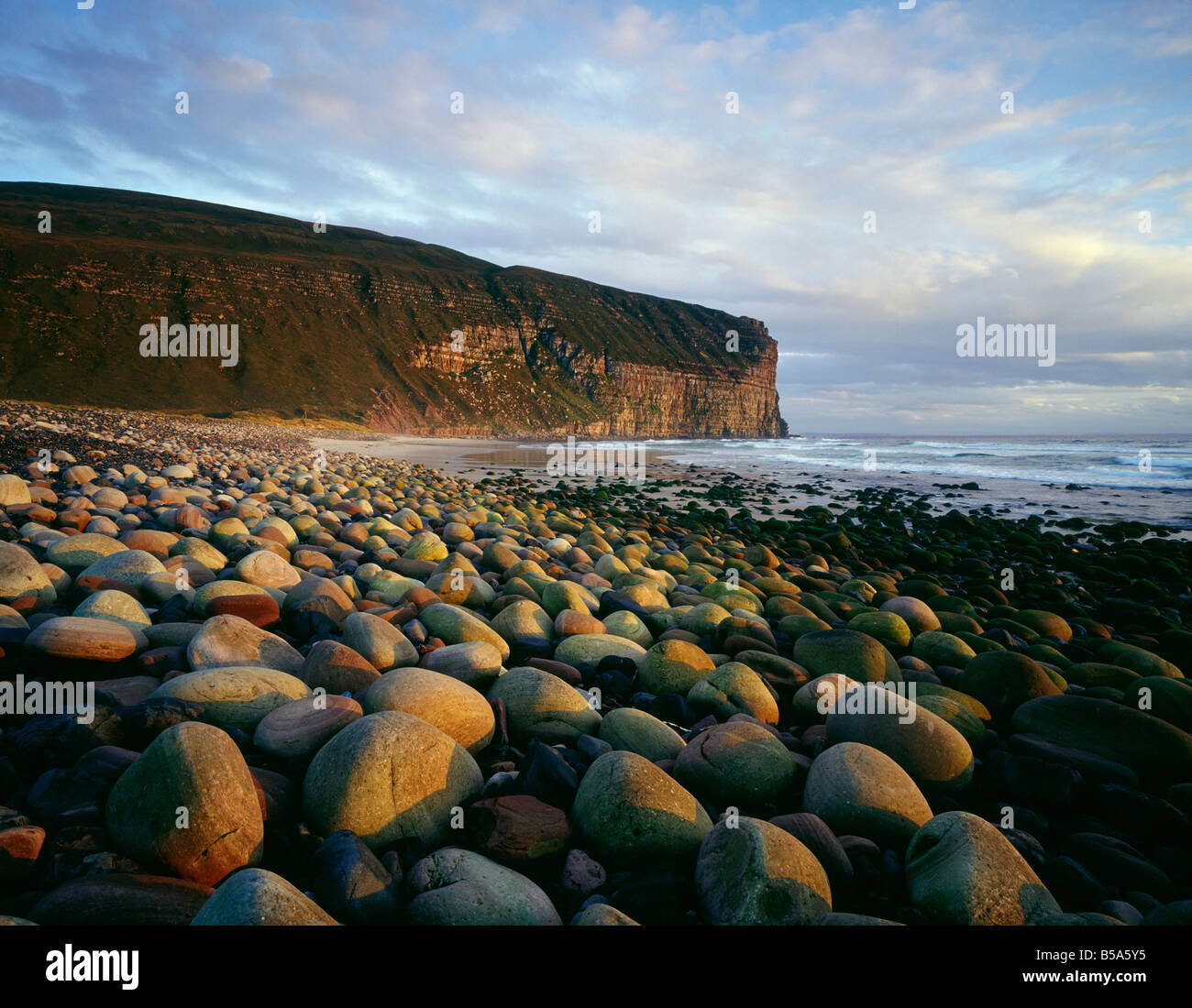 Rackwick Beach View across sand sea to steep sandstone cliffs Boulders ...