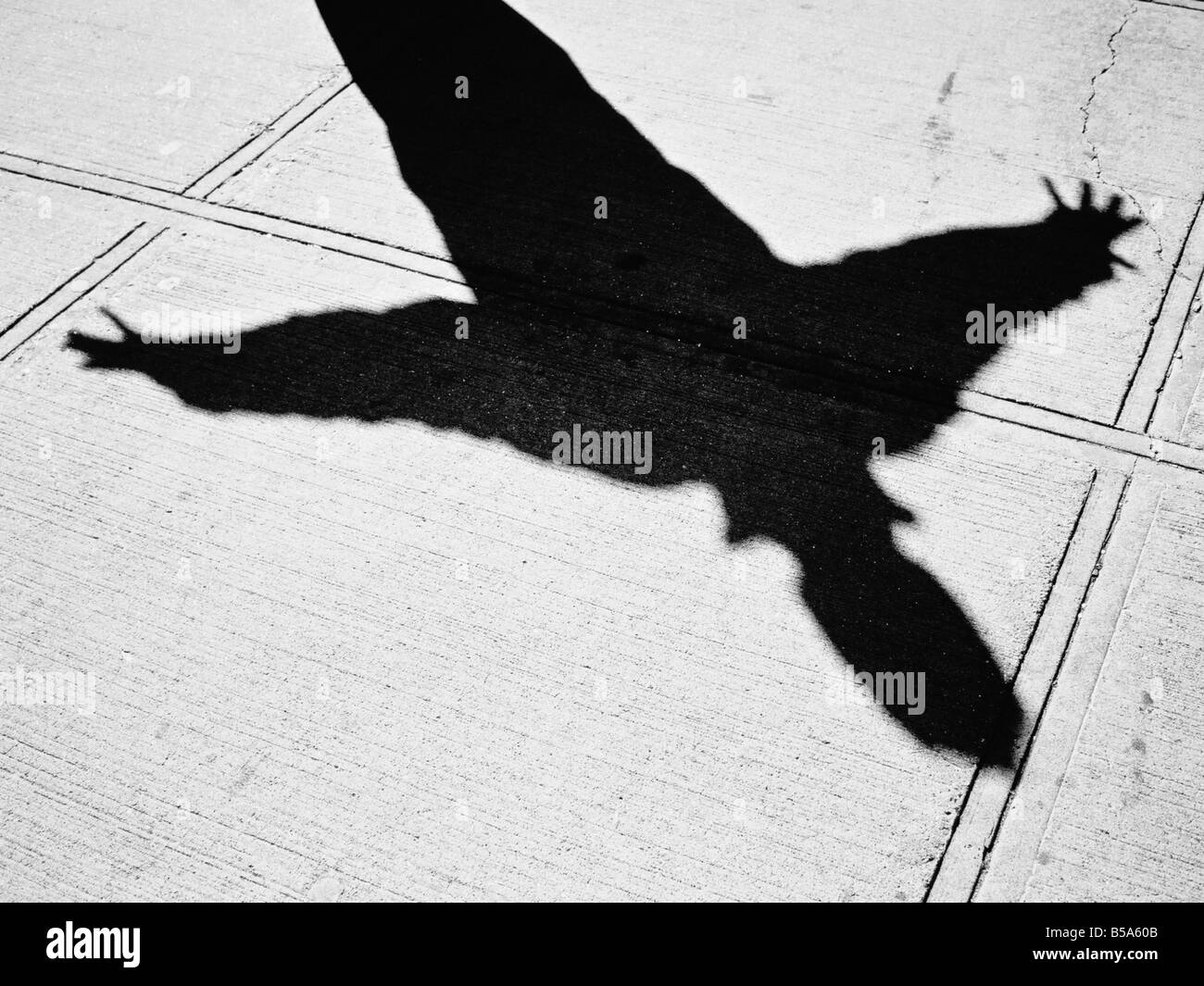 Shadow Of Man Who Spreads Out Arms On Sidewalk Stock Photo - Alamy